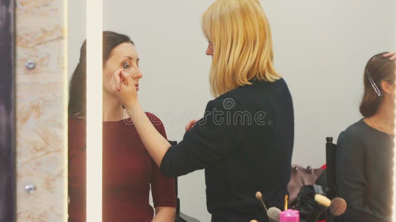 Make-up Artist at Work with the Model in the Mirror Reflection Stock ...