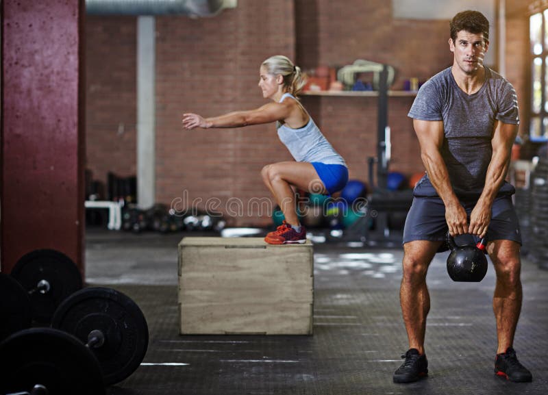 Make Your Workout Count. Two People Working Out with Kettlebells in a ...