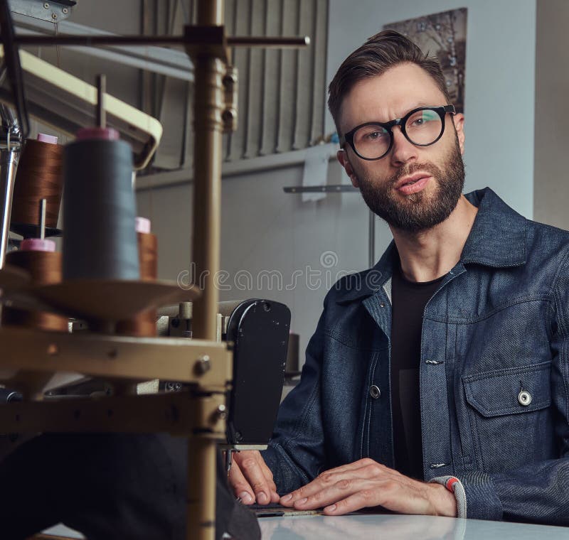 Making Clothes. Tailor Sitting at Table and Working on a Sewing Machine ...