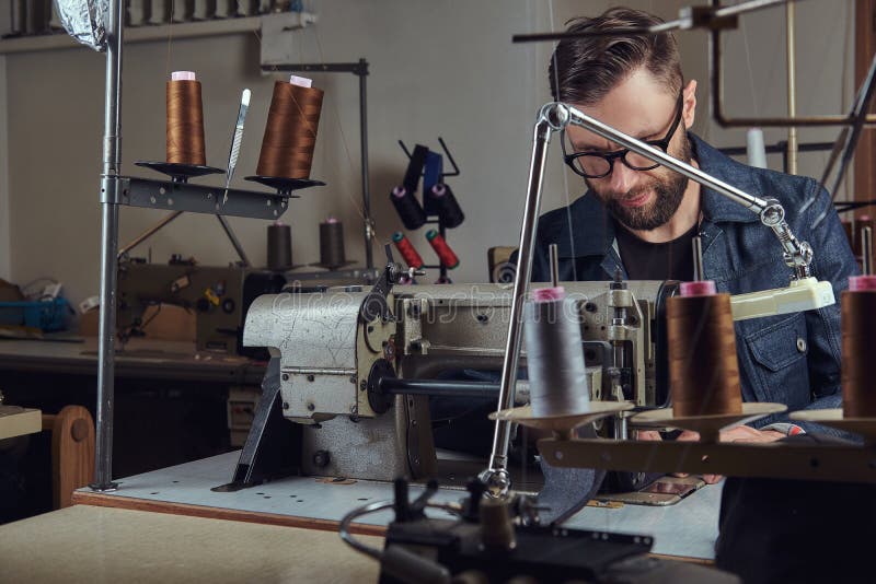 Making Clothes. Tailor Sitting at Table and Working on a Sewing Machine ...