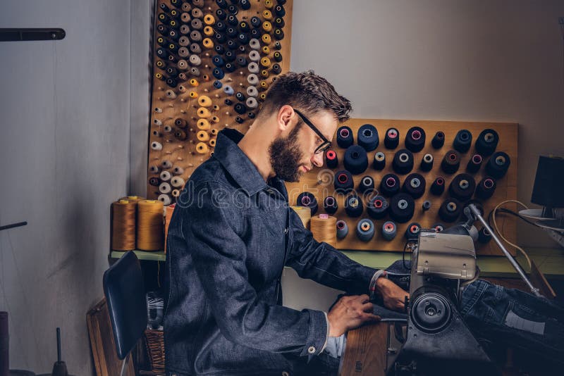 Making Clothes. Tailor Sitting at Table and Working on a Sewing Machine ...