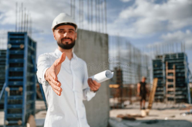 With Plan in Hands. Man in Uniform is Working on the Construction Site ...
