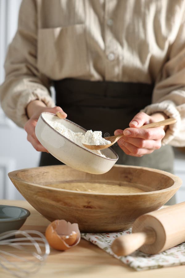 Making Dough. Woman Adding Flour into Bowl at Wooden Table in Kitchen ...