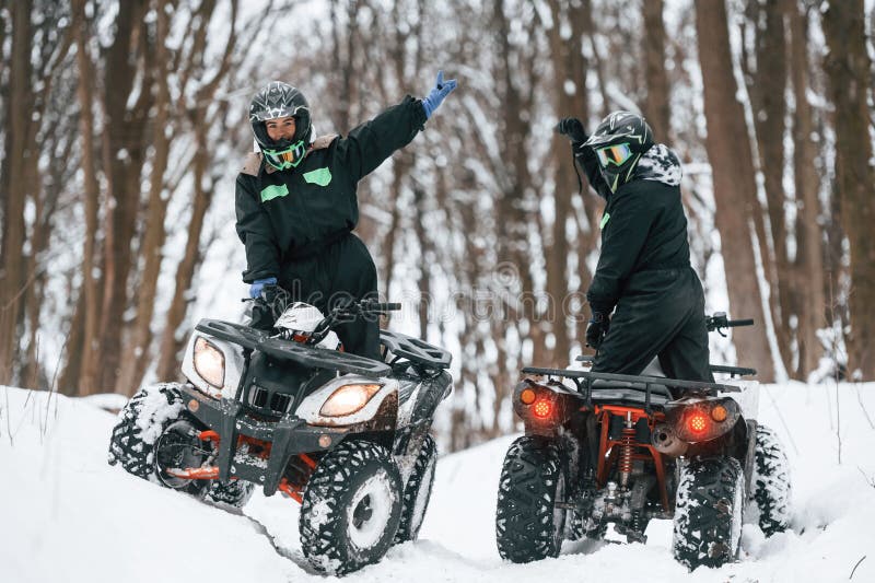 Making Gestures. Two People are Riding ATV in the Winter Forest Stock ...