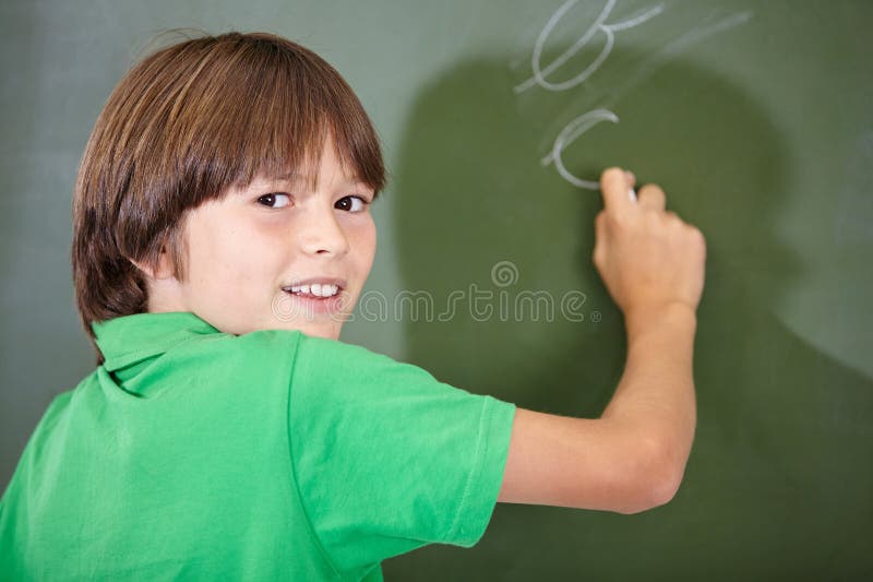 Making Good Progress. a Little Boy Writing on the Blackboard during a ...