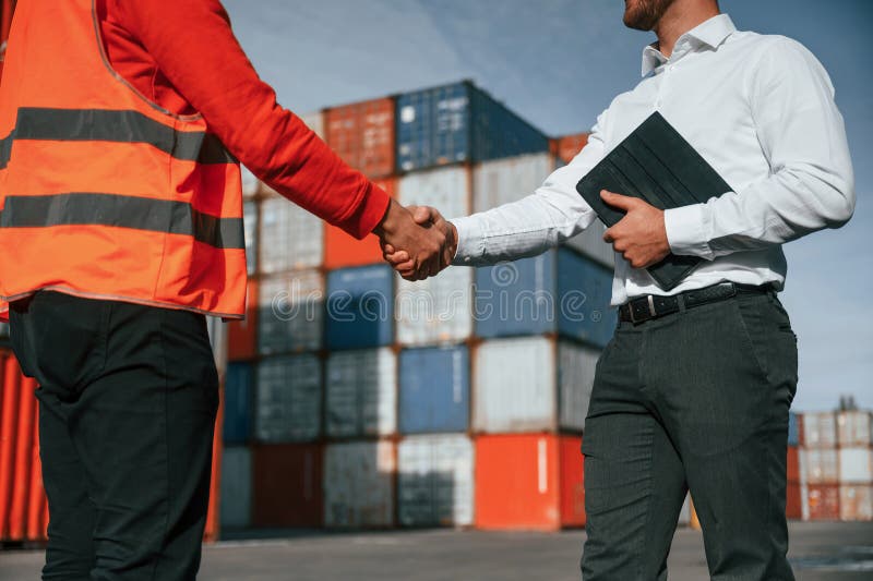 Making Handshake. Two Male Workers is on the Location with Containers ...