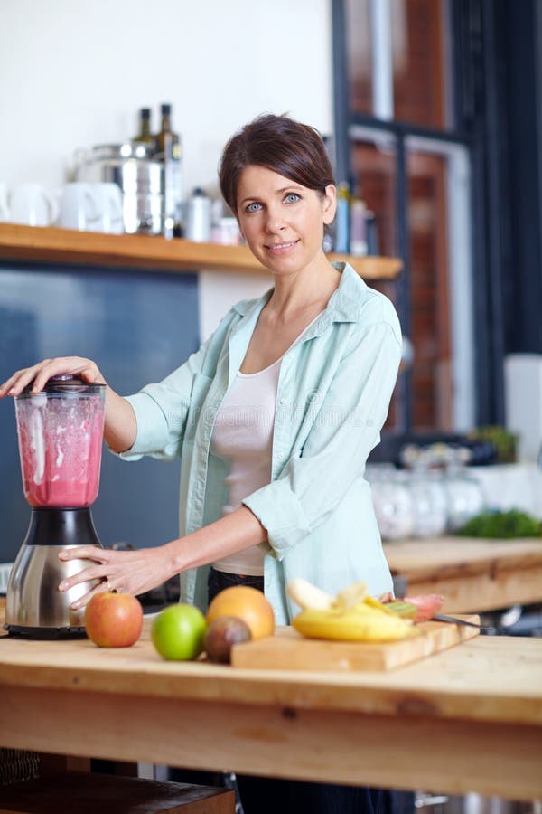 Making a Healthy Blend. an Attractive Woman Making a Fruit Smoothie in ...