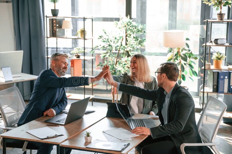 Making High Five, Sitting by the Table. Group of Business People are ...