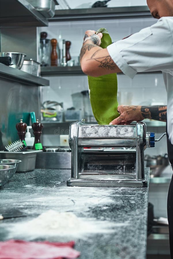 Homemade Pasta. Portrait of Concentrated Young Chef Rolling a Black ...