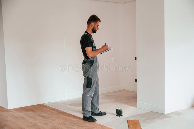 Making Notes into the Document and Using Laser Leveler. Man is ...