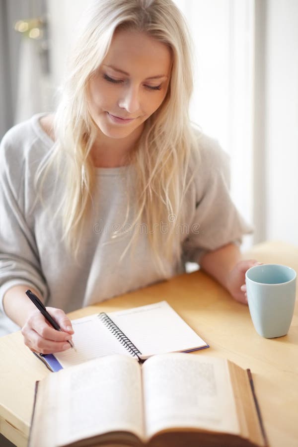Making Notes. a Pretty Young Woman Making Notes from a Book while ...