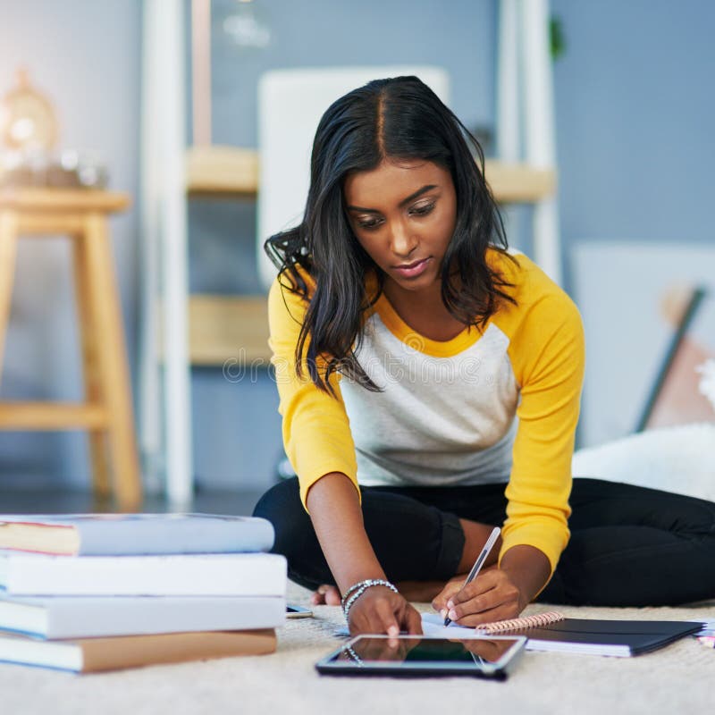 Making Notes while Studying Helps. a Young Female Student Studying at ...