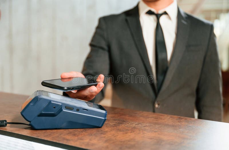 Making Payment by Using Phone and Terminal. a Man in a Black Jacket at ...