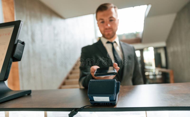 Making Payment by Using Phone and Terminal. a Man in a Black Jacket at ...
