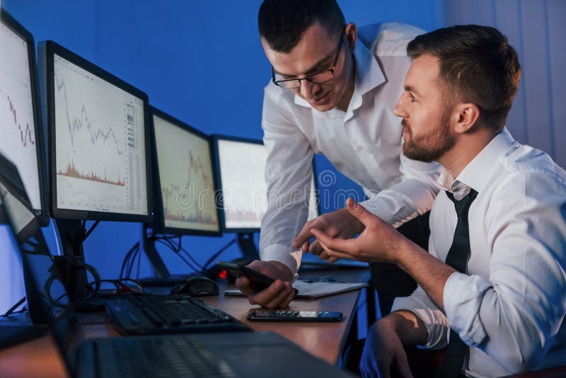 Making Profit. Two Stock Traders Working in the Office with Exchange ...