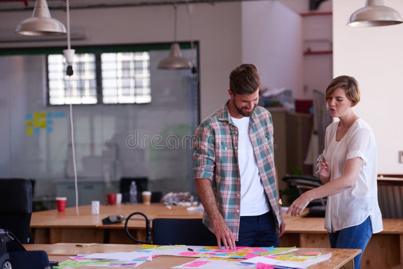 Making the Project Work for Them. a Young Woman Looking at Sticky Notes ...