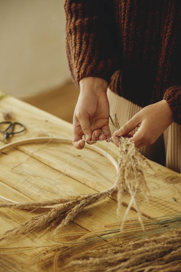 Making Stylish Autumn Wreath on Rustic Table. Hands Arranging Dried ...