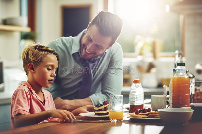 Making Sure His Son Has a Good Breakfast. a Man Sitting with His Son ...