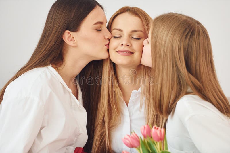 Making Surprise With Flowers Young Mother With Her Two Daughters At