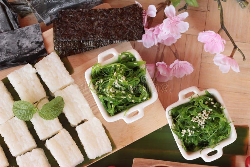 Making Sushi Roll and Seaweed Salad with Rice. Stock Photo - Image of ...