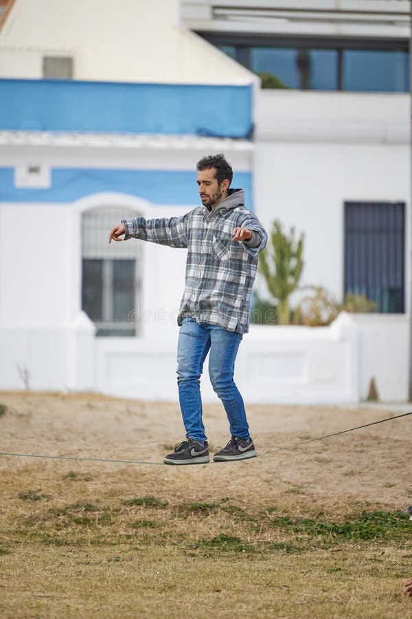 Male Acrobat Balances Standing on a Rope Editorial Stock Image - Image ...