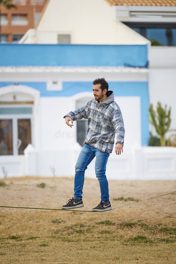 Male Acrobat Balances Standing on a Rope Editorial Stock Image - Image ...