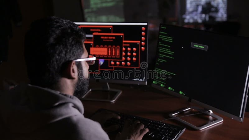 Male Arabic Hacker Hacks Computer in Dark. Computer Code Reflecting on ...