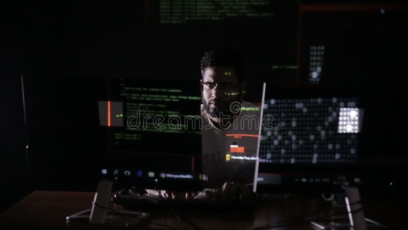 Male Arabic Hacker Hacks Computer in Dark. Computer Code Reflecting on ...
