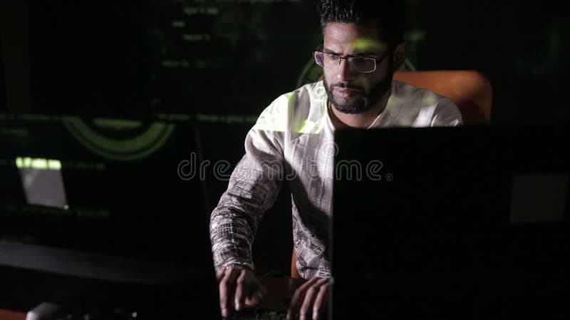 Male Arabic Hacker Hacks Computer in Dark. Computer Code Reflecting on ...