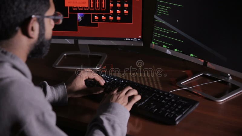 Male Arabic Hacker Hacks Computer in Dark. Computer Code Reflecting on ...