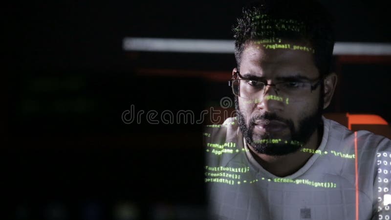 Male Arabic Hacker Hacks Computer in Dark. Computer Code Reflecting on ...