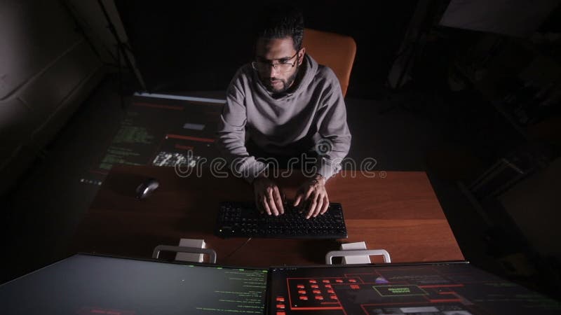 Male Arabic Hacker Hacks Computer in Dark. Computer Code Reflecting on ...