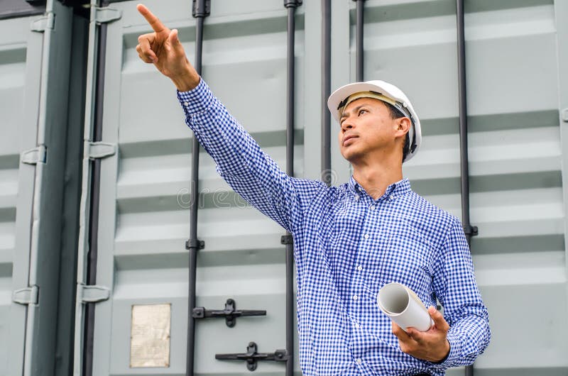 Male Architect and Blueprints with White Helmet Pointing Finger on a ...