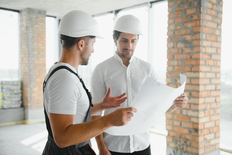 Male Architect Giving Instructions To His Foreman at Construction Site ...