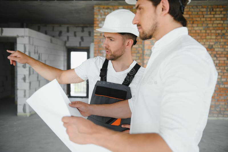 Male Architect Giving Instructions To His Foreman at Construction Site ... Male Architect Giving Instructions To His Foreman at Construction Site ...