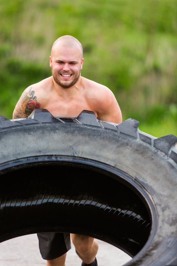 Tire Flip Exercise. Sportsman is Engaged in Workout with Heavy Tire in ...