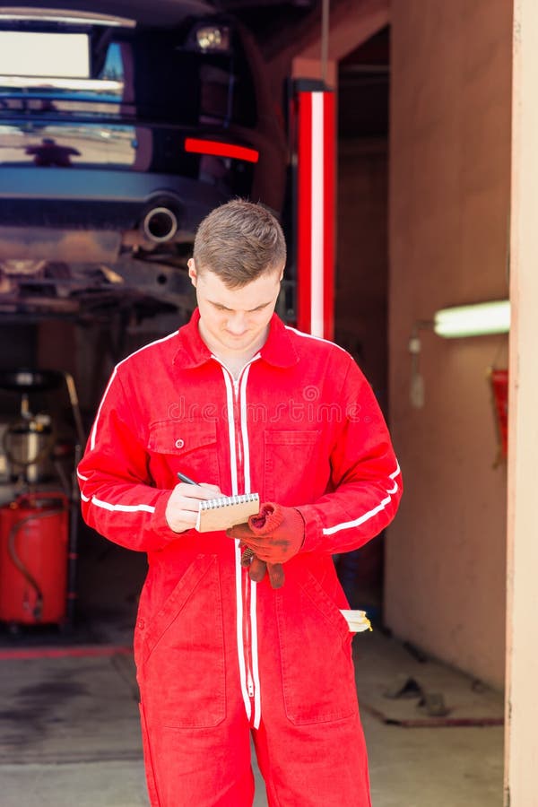 Male Auto Mechanic Standing Making Notes Stock Image - Image of station ...