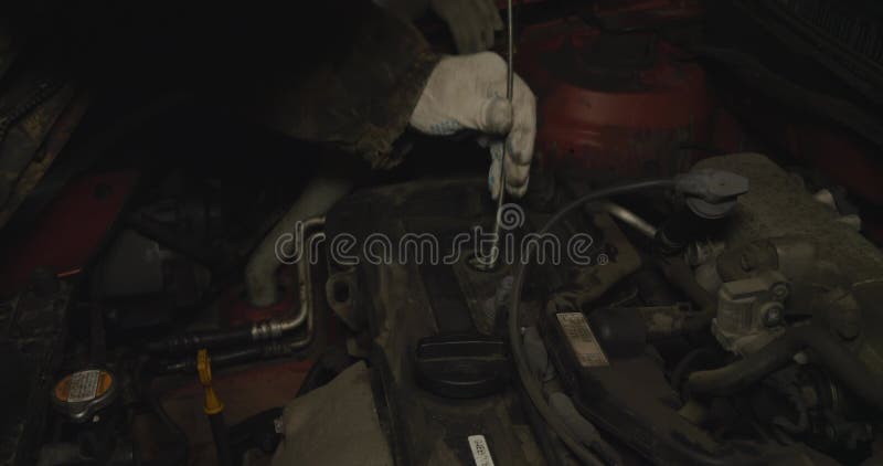 A Male Auto Mechanic Will Carefully Replace Spark Plugs To Optimize the ...