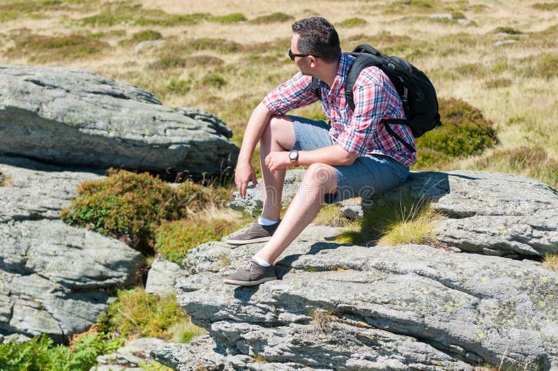 Male Backpacker Enjoying the Mountain Sitting on Rock Stock Photo ...