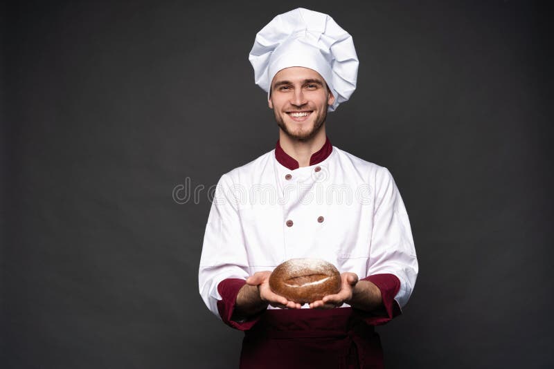 Male Baker Holding Bread Loaf and Looking at Camera Isolated on Black ...