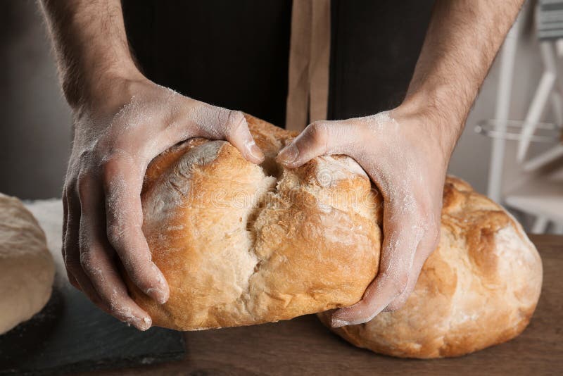 Male Baker Holding Loaf of Bread Over Table Stock Photo - Image of ...