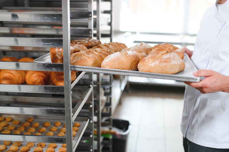 Male Baker Holding a Tray of Baked Breads in Bakery Shop Stock Photo ...