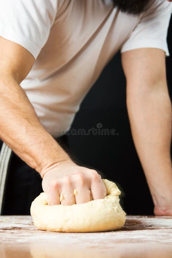 Male Baker Punching Dough from the Table Stock Photo - Image of kitchen ...