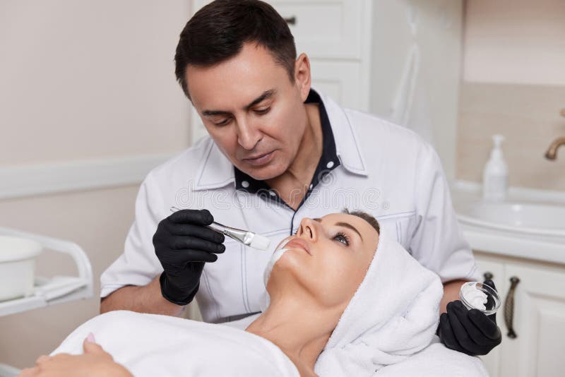 Beautician Applies The Mask To Face Of Woman In The Spa Salon Skin