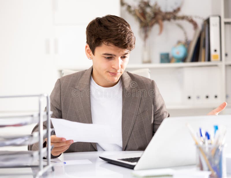 Male Bookkeeper Doing Paperwork in Workplace in Office - Checks ...
