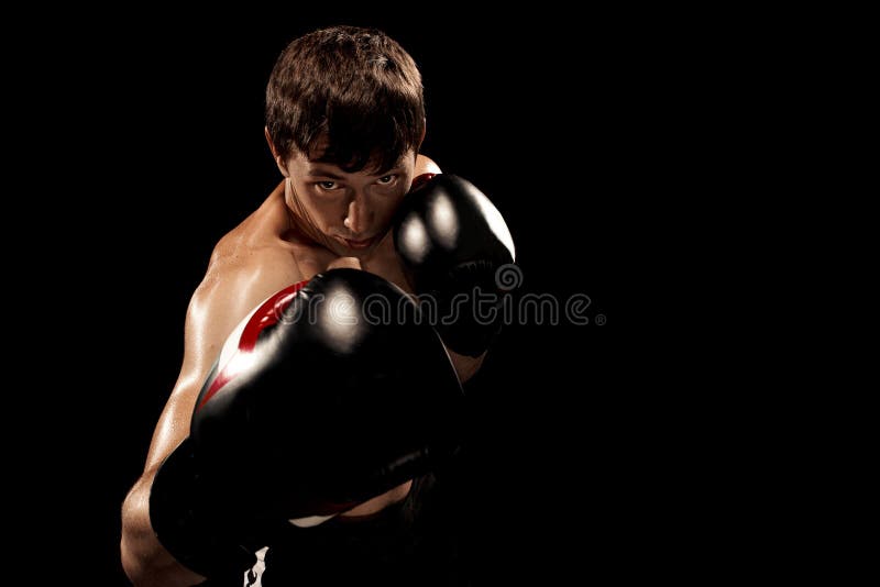 Male Boxer Boxing in Punching Bag with Dramatic Edgy Lighting in a Dark ...