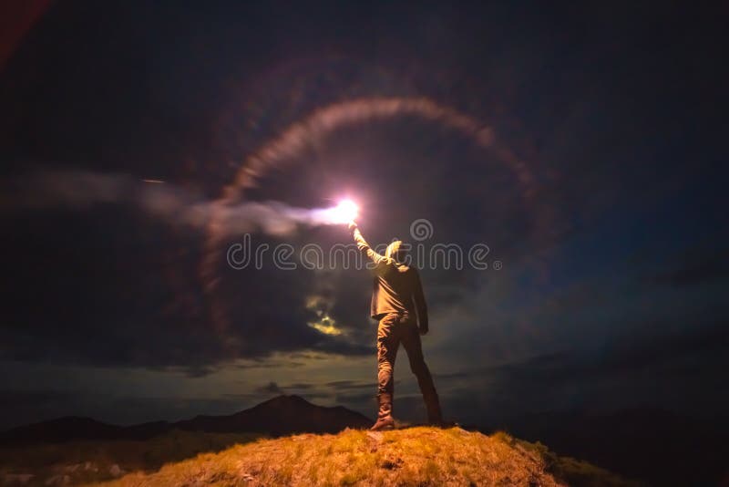 The Male with a Bright Firework Stick Standing on a Mountain. Evening ...