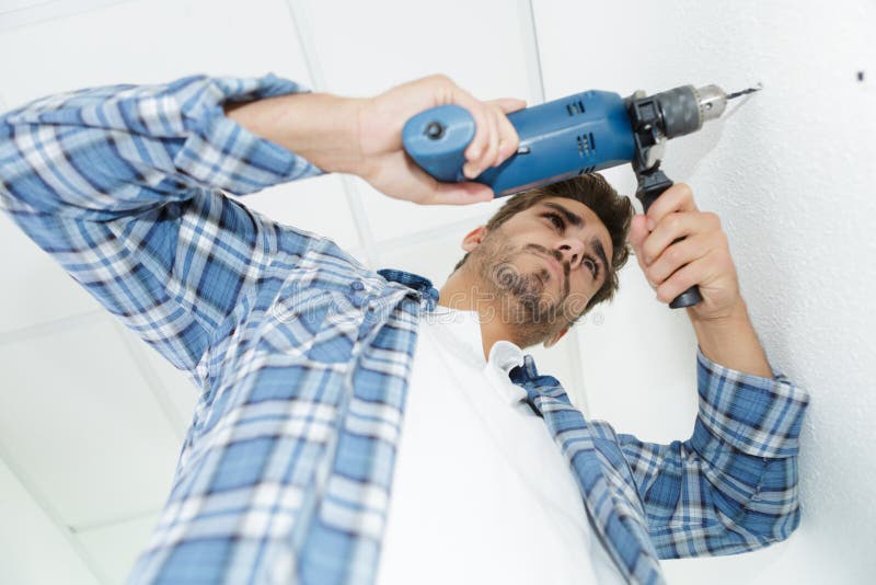 Male Builder Drilling Holes in Wall at Construction Site Stock Photo ...