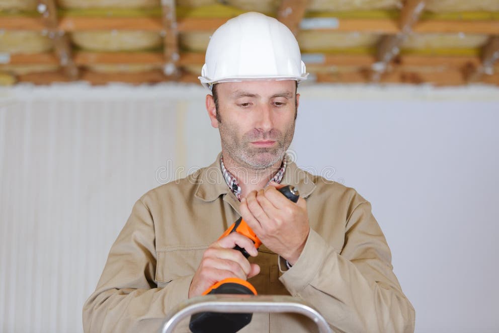 Male Builder Drilling Holes in Wall at Construction Site Stock Image ...