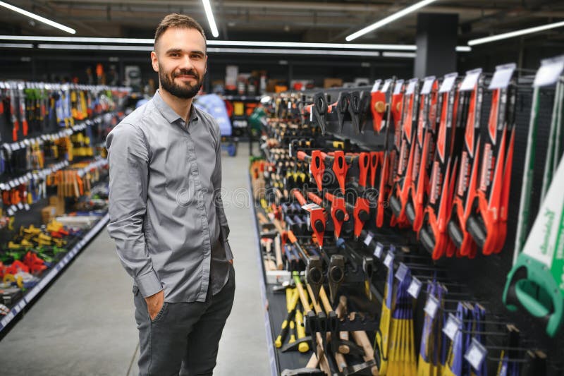 Male Builder in a Hardware Store Chooses a Tools Stock Photo - Image of ...